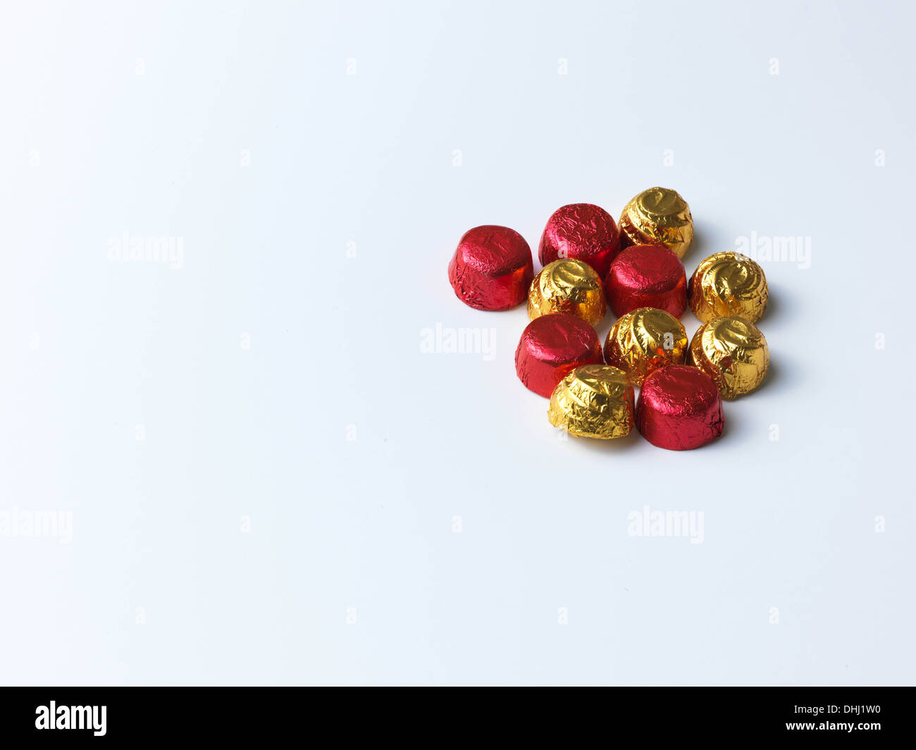 A selection of chocolates against a white background in yellow and red ...