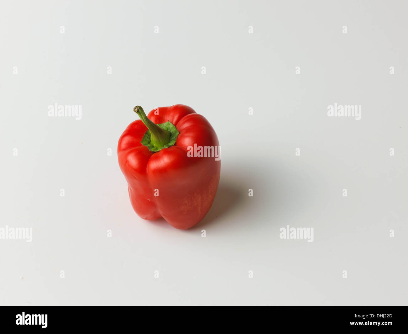 A red pepper standing up against a white background with a shadow Stock ...