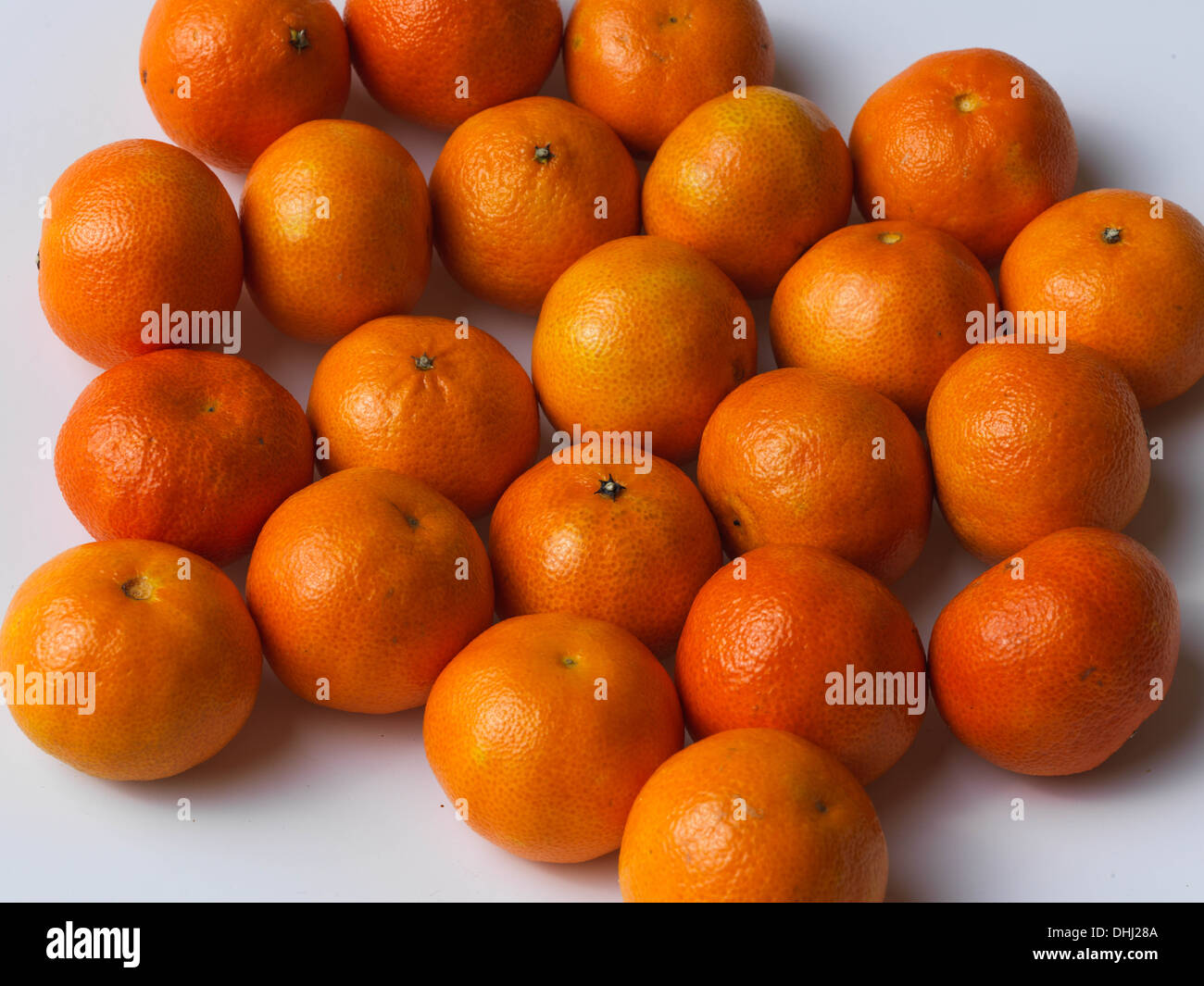 A large batch of orange clementines sit on a white background Stock ...