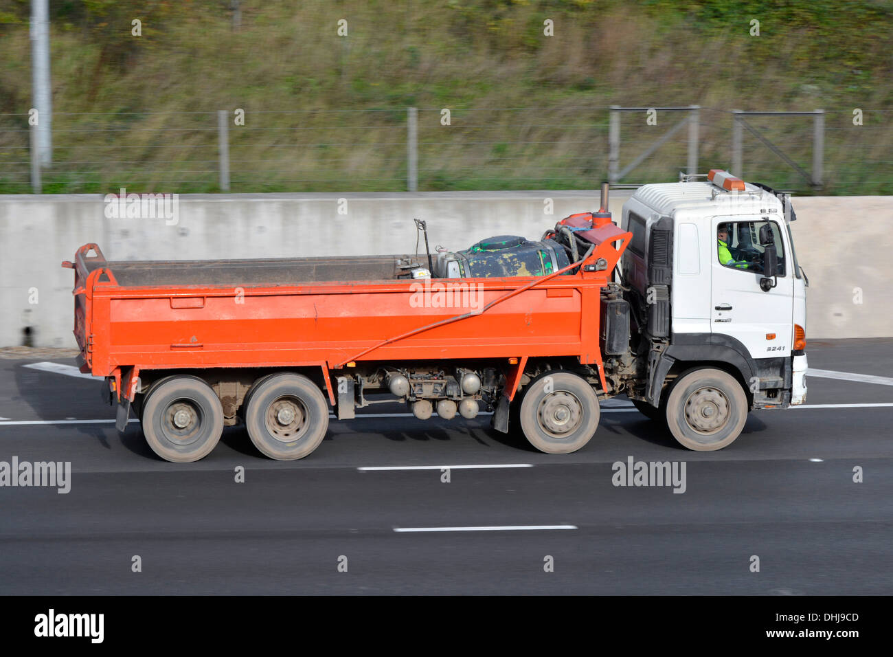Male lorry driver in side view of white truck at work in high ...