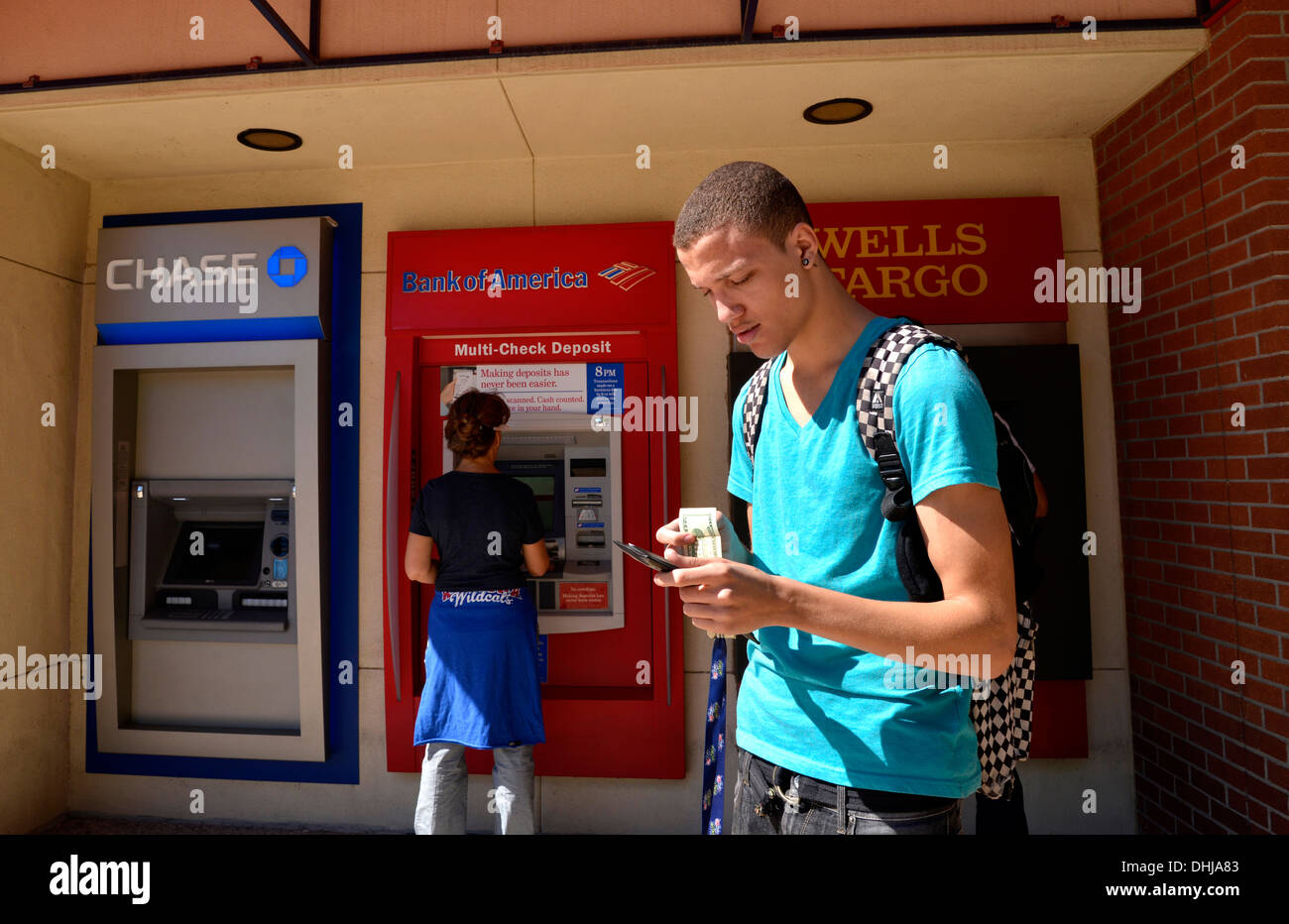 A young man with a wallet and money on a college campus Stock Photo - Alamy