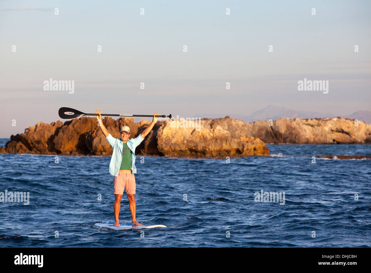 man doing stand up paddle with paddle on top Stock Photo - Alamy