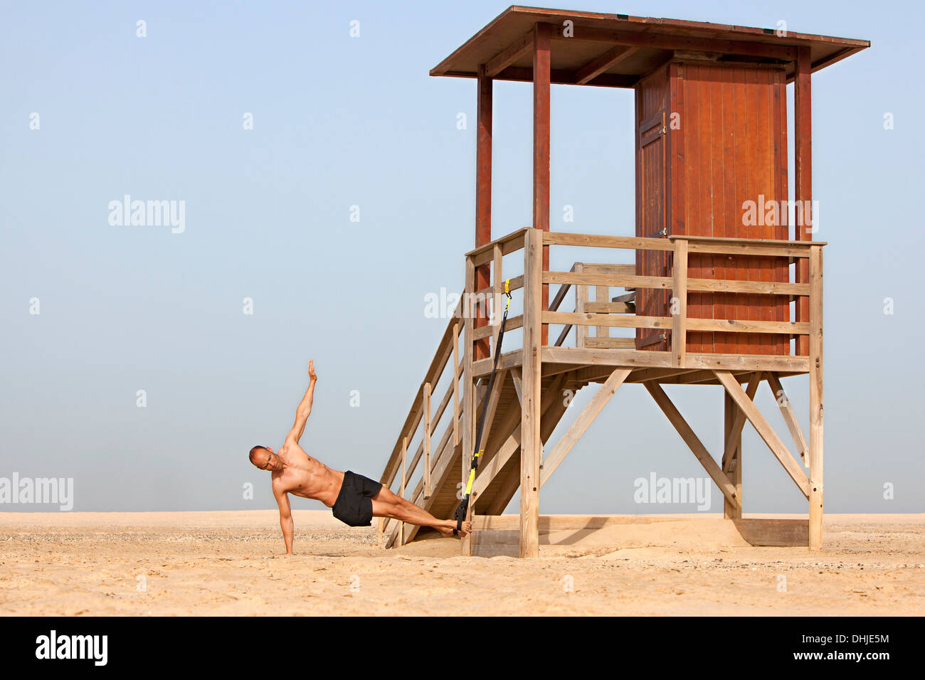 man playing sports on the beach with trx Stock Photo - Alamy