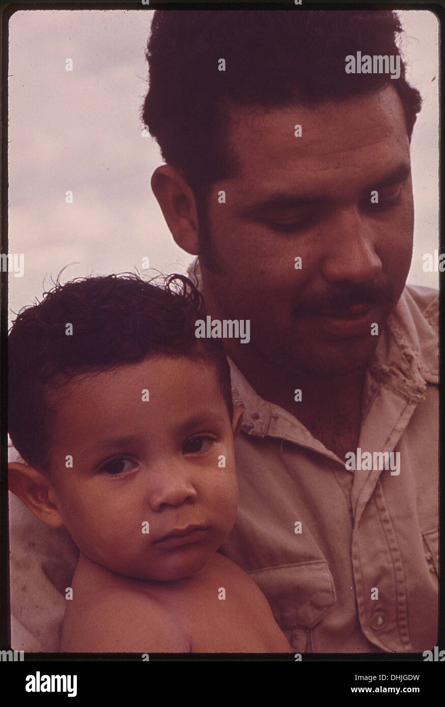 A poignant photograph of a migrant father and his young son, reflecting ...