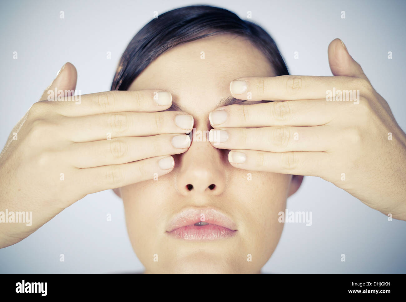 A young woman covering her eyes with her hands Stock Photo - Alamy