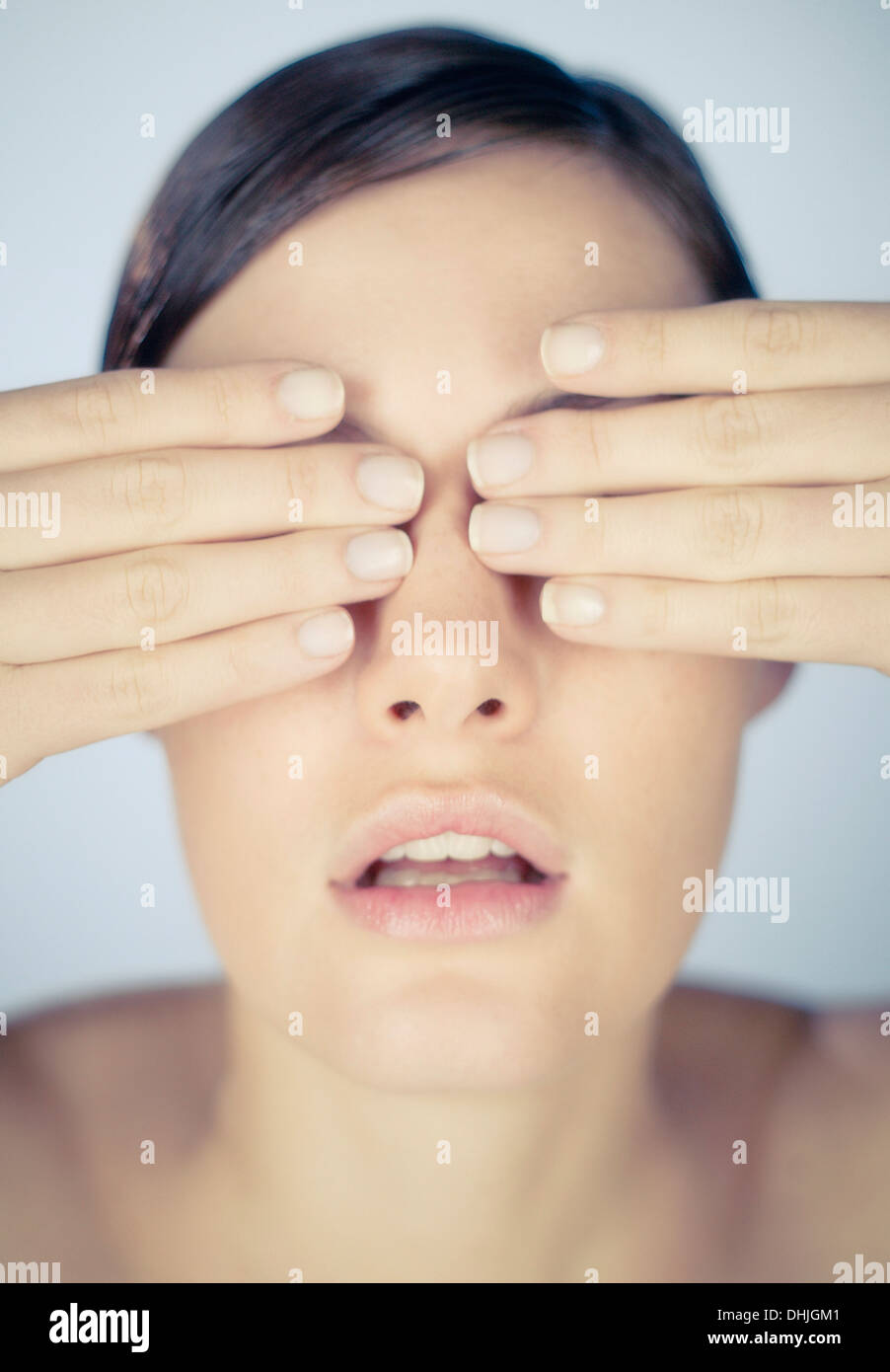 A young woman covering her eyes with her hands Stock Photo - Alamy