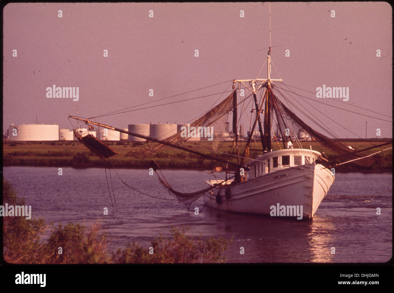 A shrimp boat is seen with a petroleum installation in the background ...