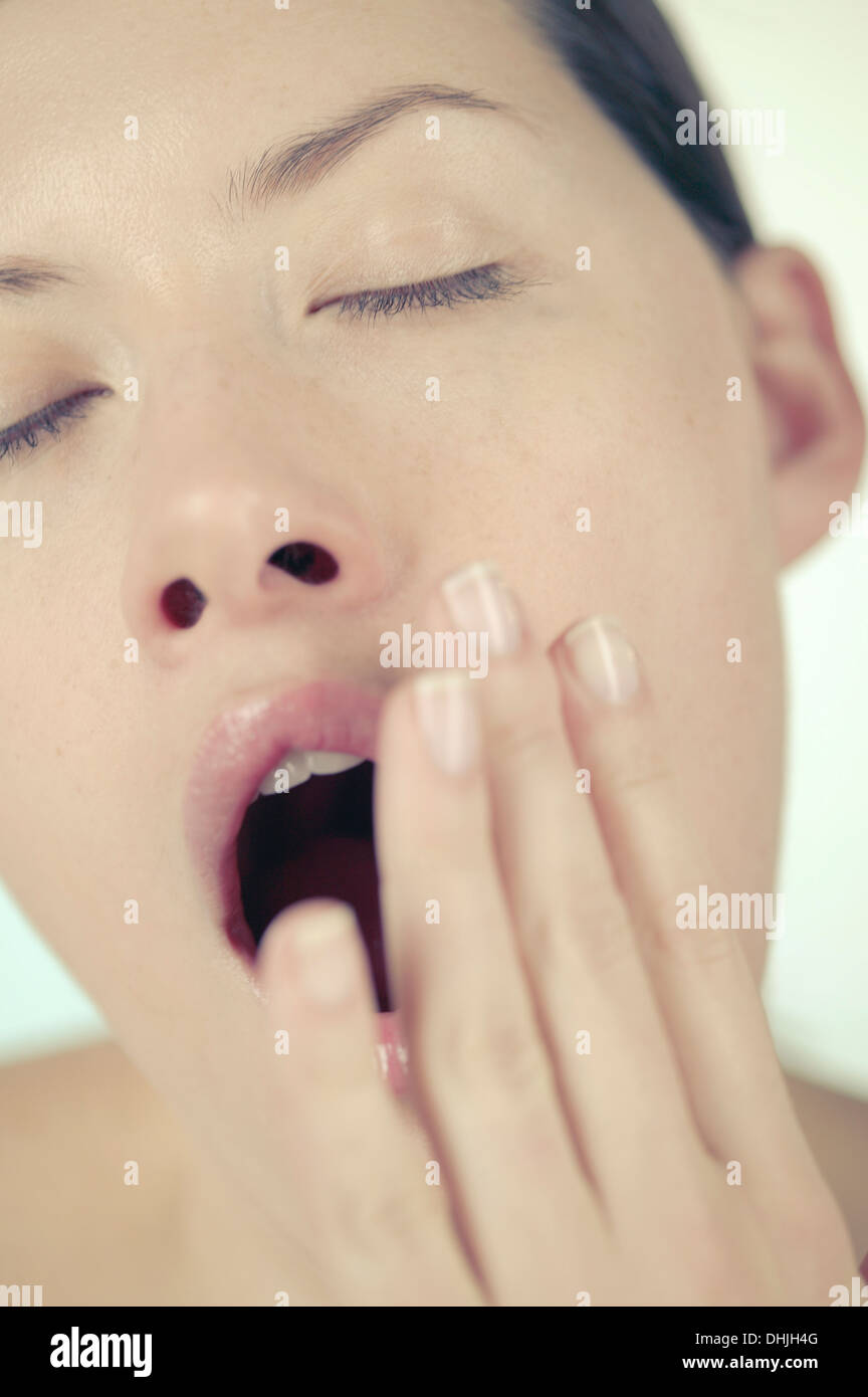 A young woman yawning Stock Photo - Alamy
