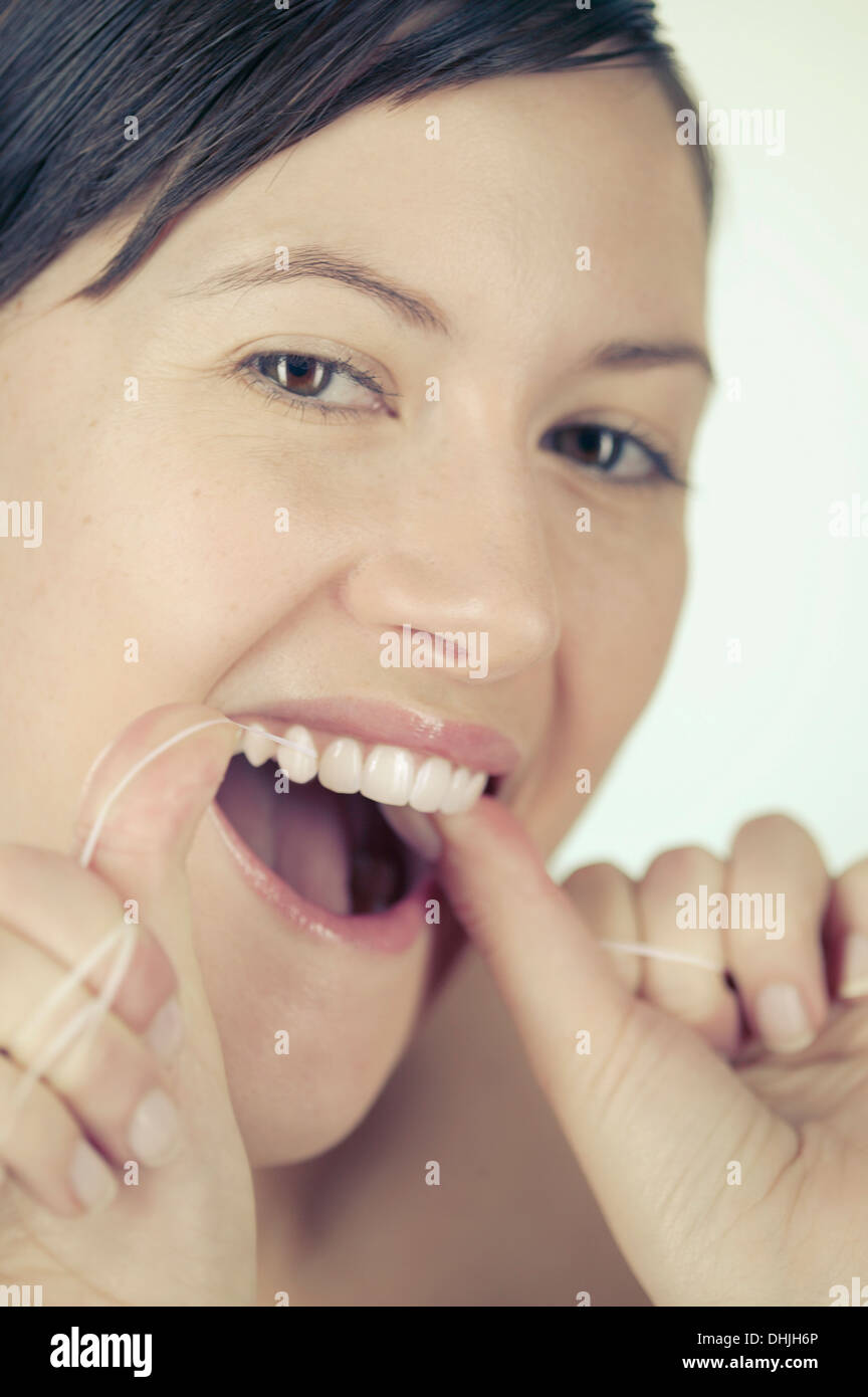 A young woman flossing her teeth Stock Photo - Alamy