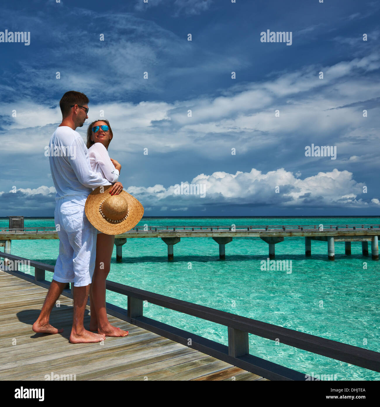 Couple on a beach jetty at Maldives Stock Photo - Alamy
