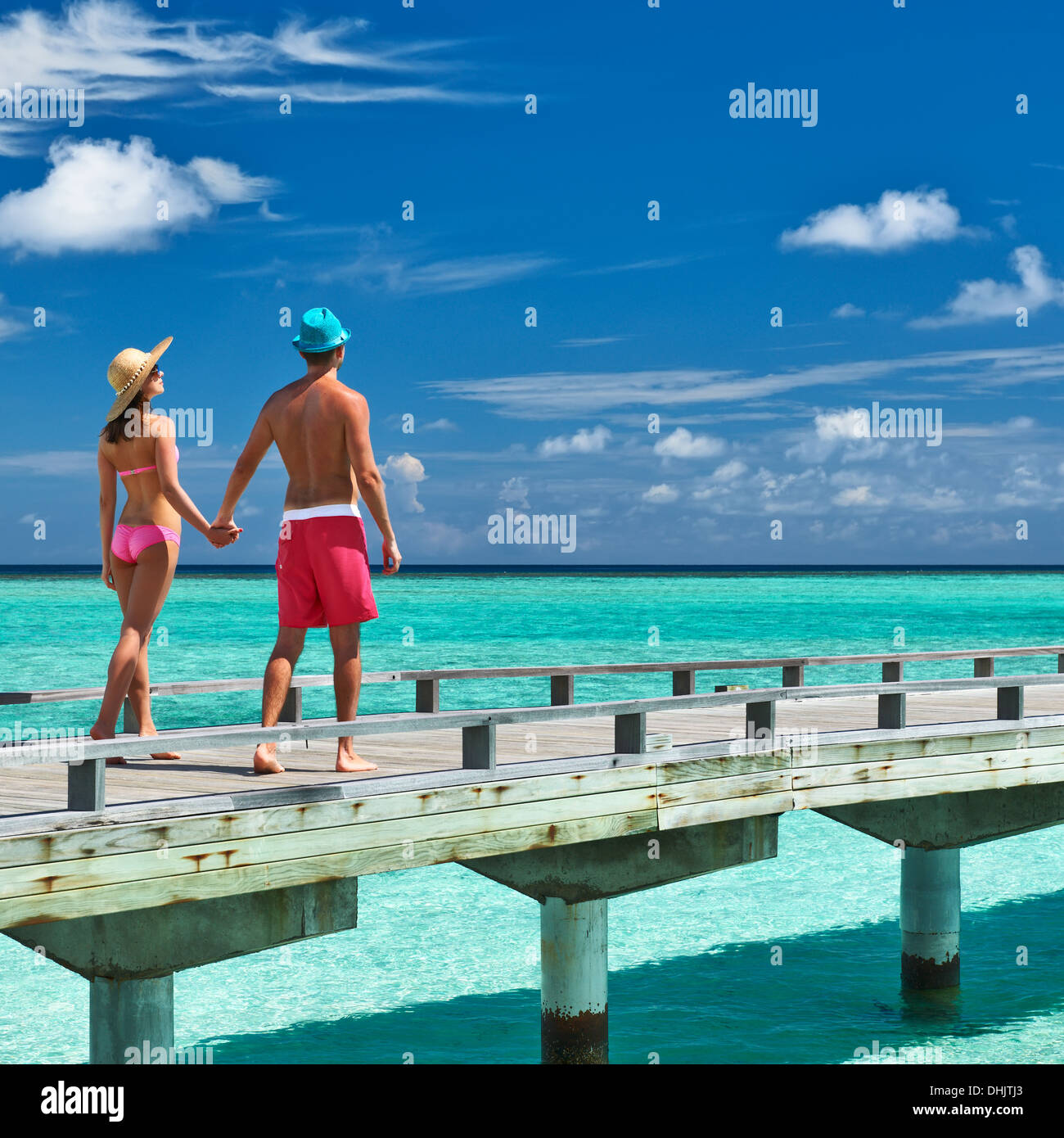 Couple on a beach jetty at Maldives Stock Photo - Alamy
