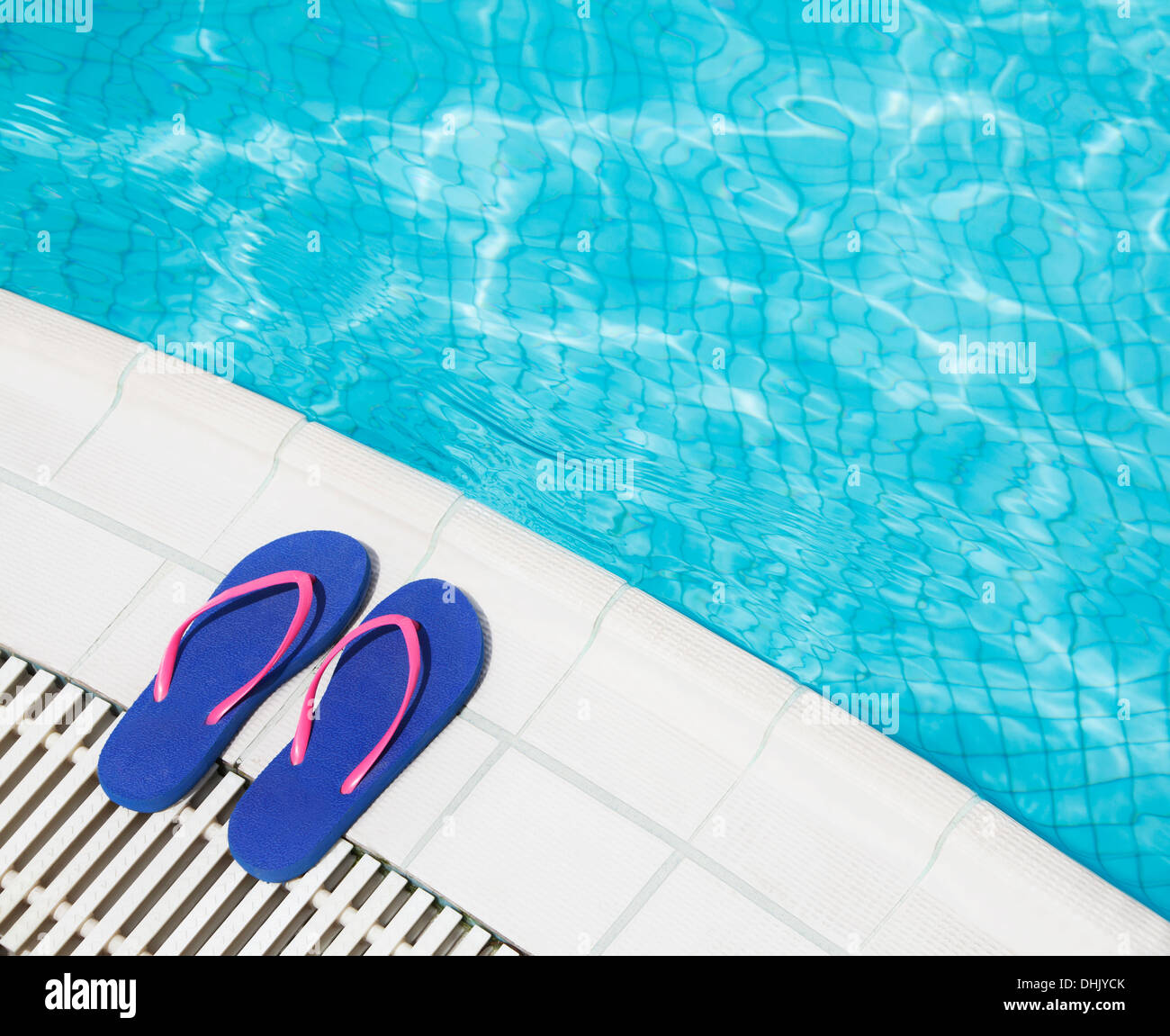 Pair of blue flip flops by the pool side Stock Photo - Alamy