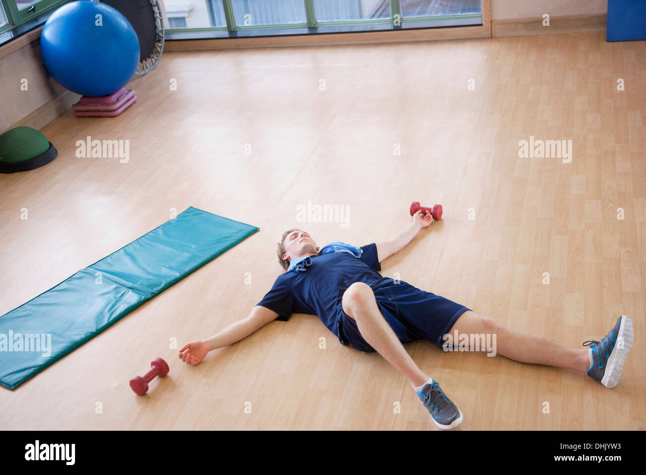 Tired young man lying on his back in the gym Stock Photo - Alamy