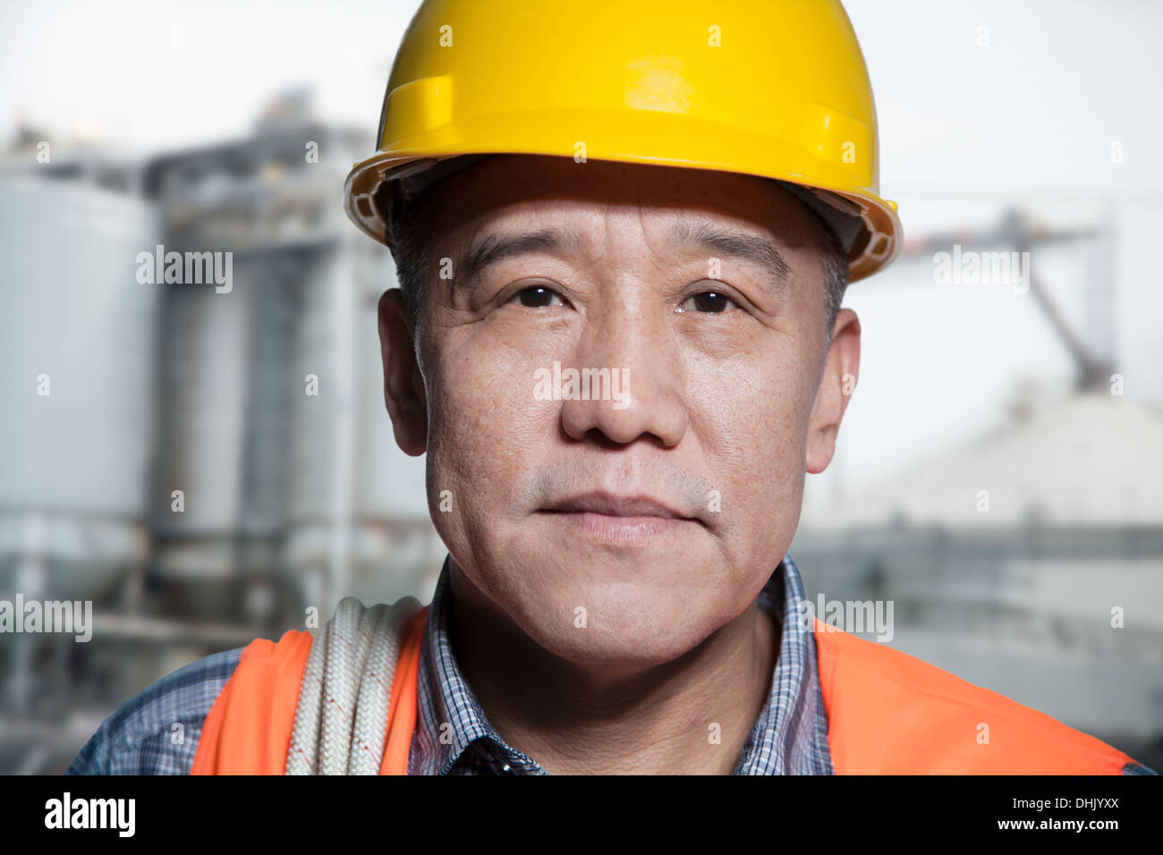 Portrait of proud worker in protective workwear outside of a factory ...