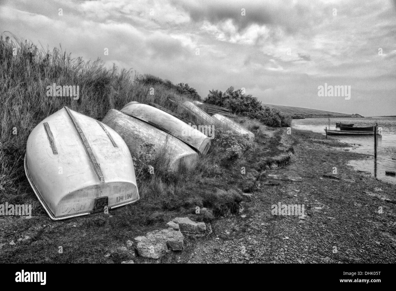Upturned boats at the edge of The Fleet Stock Photo - Alamy