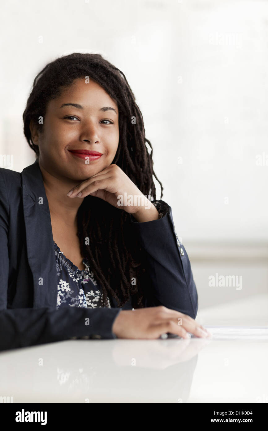Portrait of smiling businesswoman with dreadlocks, head and shoulders ...