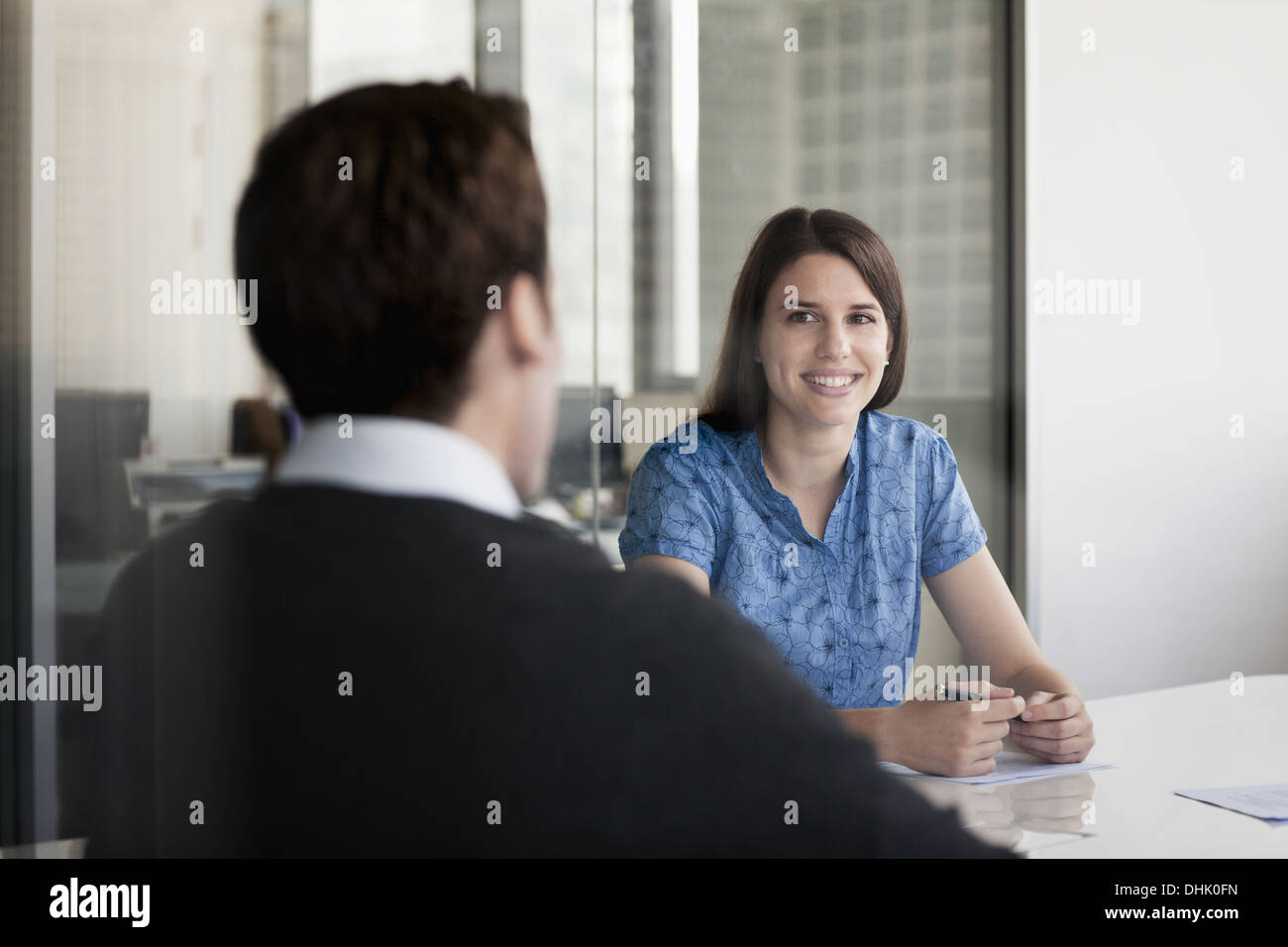 Two business people sitting at a conference table and discussing during ...