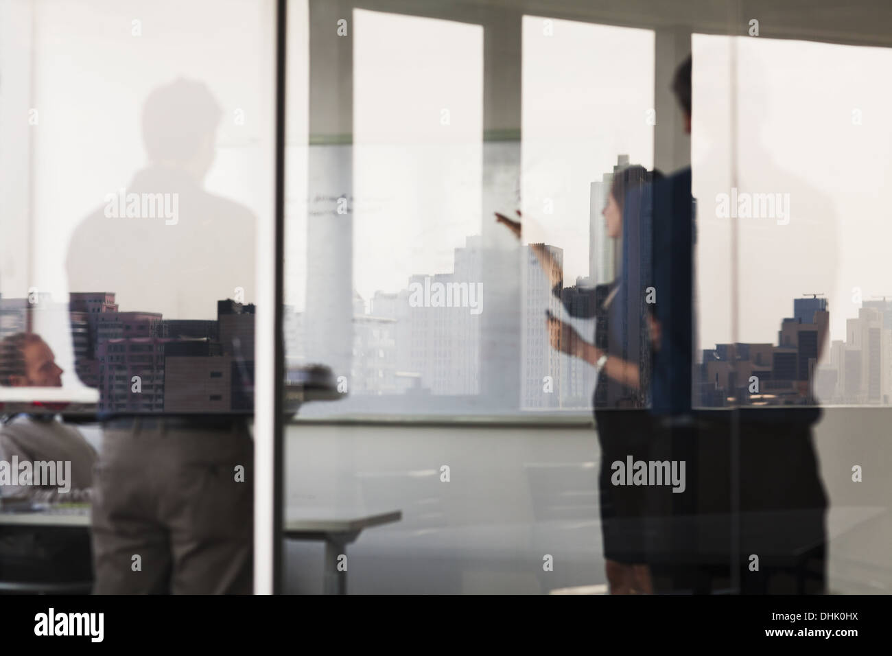 Four business people standing and looking at a white board on the other ...