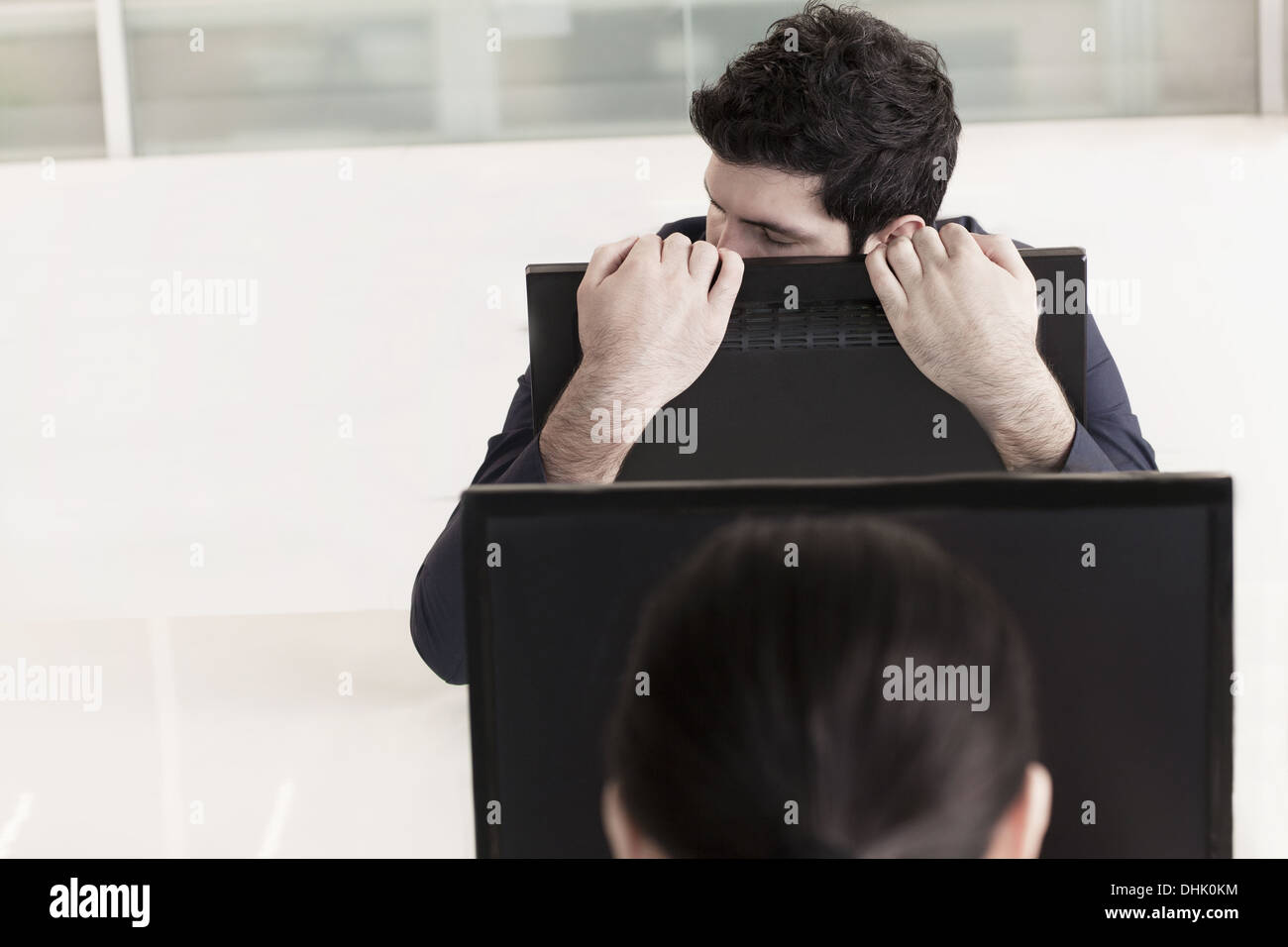 Tired businessman holding his computer monitor and resting Stock Photo ...