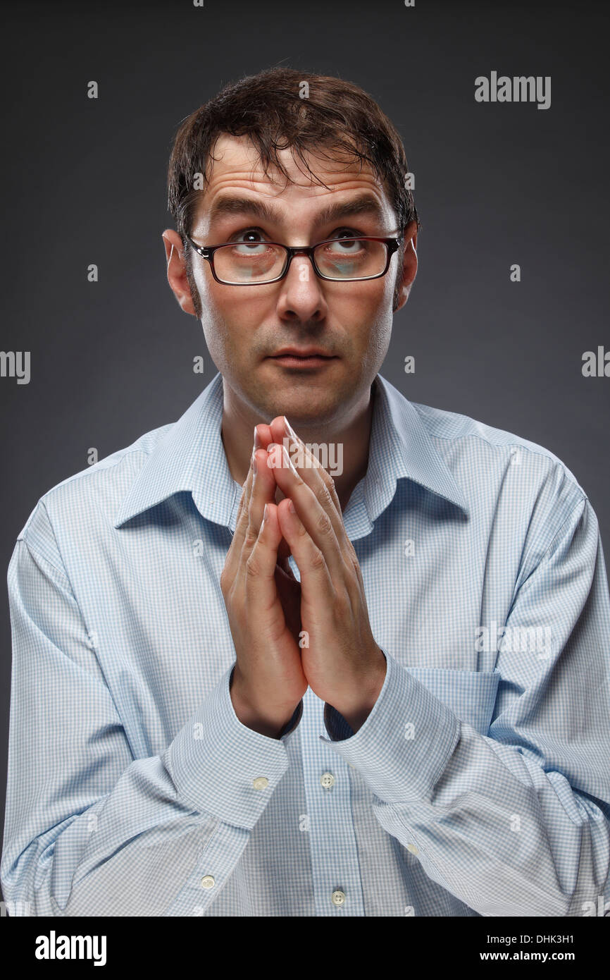 Portrait of praying man wearing glasses, studio shot Stock Photo - Alamy
