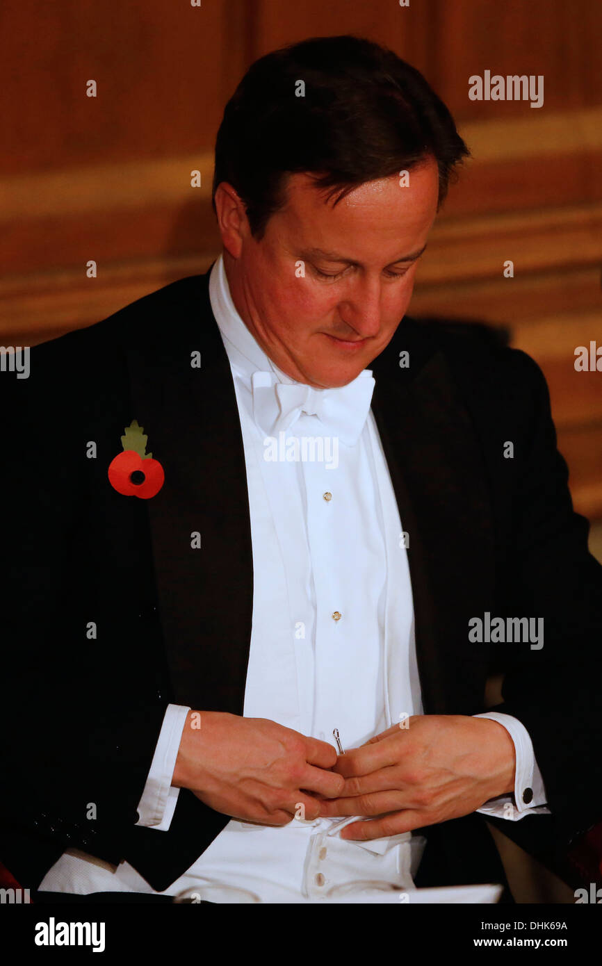 British Prime Minister David Cameron buttons his shirt at the Lord ...