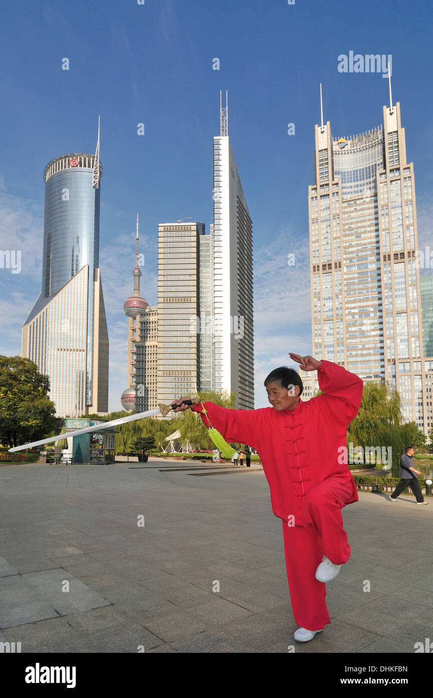 Older woman practicing sword fighting techniques in Lujiazui Park ...