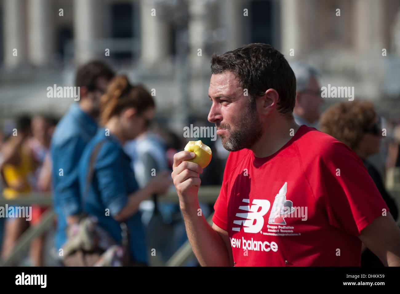 Athlete eating an apple after race in Vatican city Stock Photo - Alamy