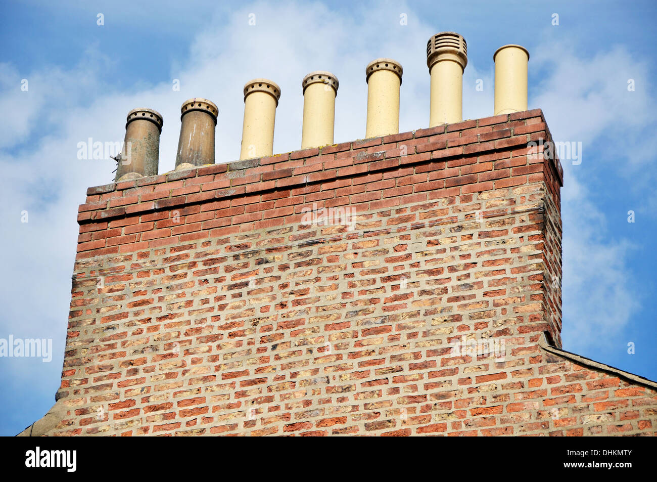 Low angle view of chimney pots of an end of terrace house against a ...