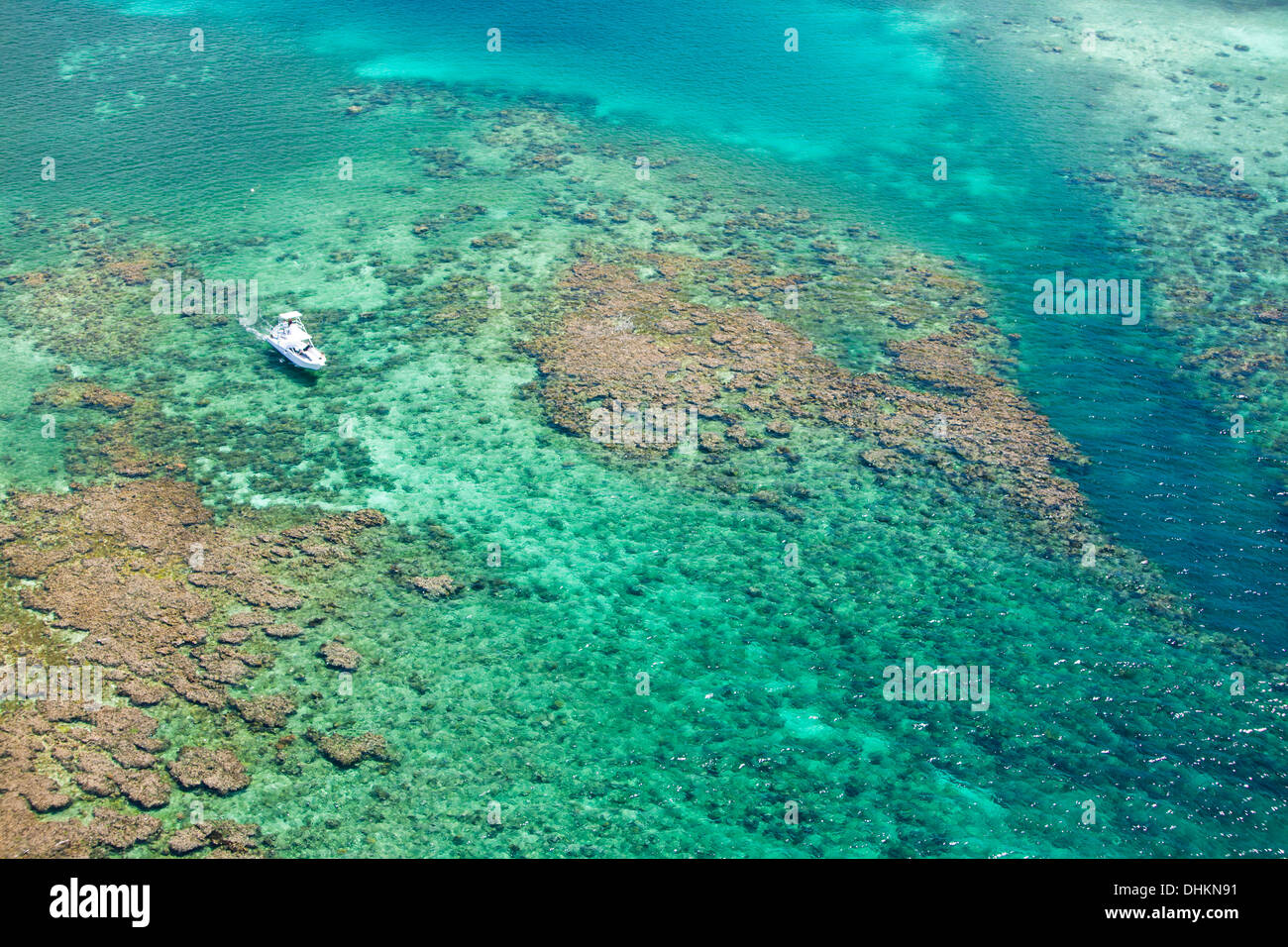 Aerial view of dive boat navigating shallow coral reef in Roatan's ...