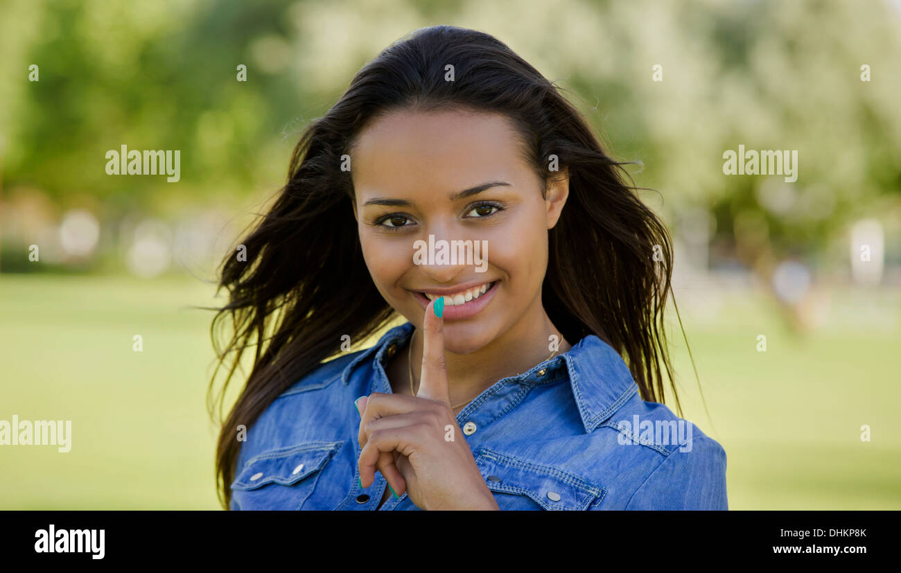 Outdoor portrait of a beautiful African American woman asking silence ...