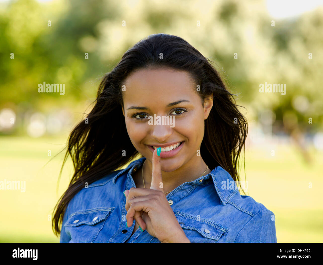 Outdoor portrait of a beautiful African American woman asking silence ...