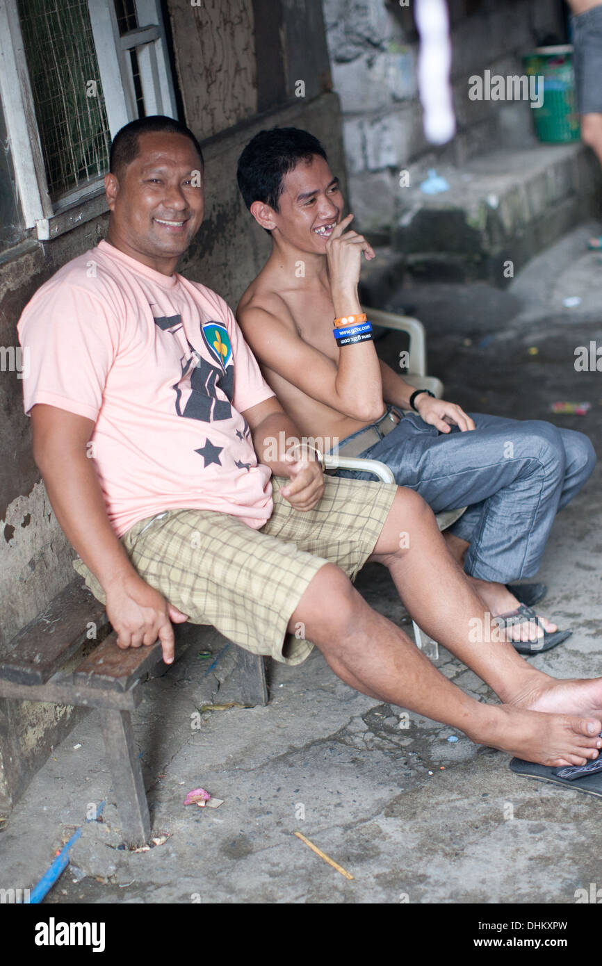 Two local men sit together on a bench in Manila Stock Photo - Alamy