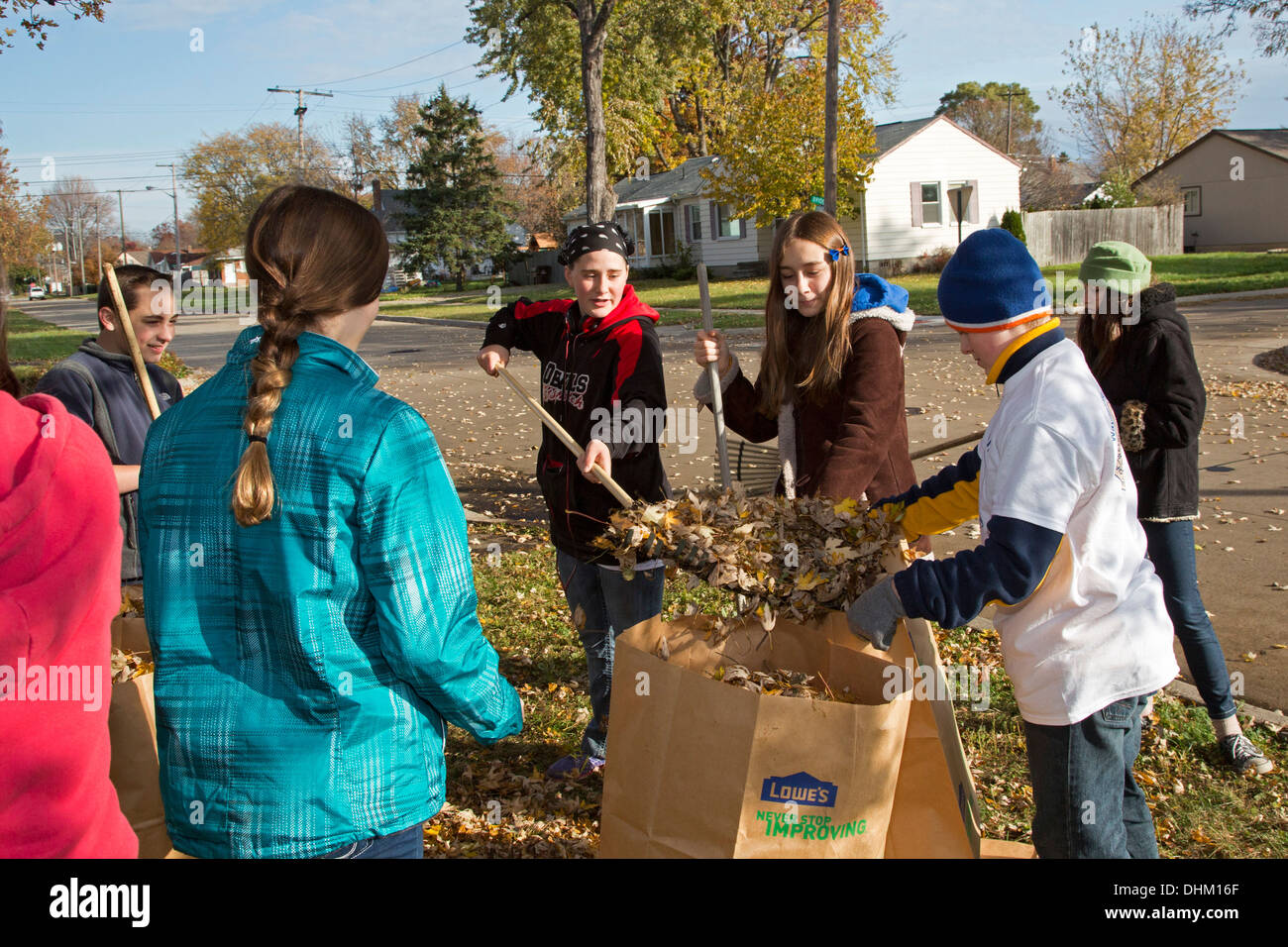 High school student volunteers rake leaves for senior citizens Stock ...
