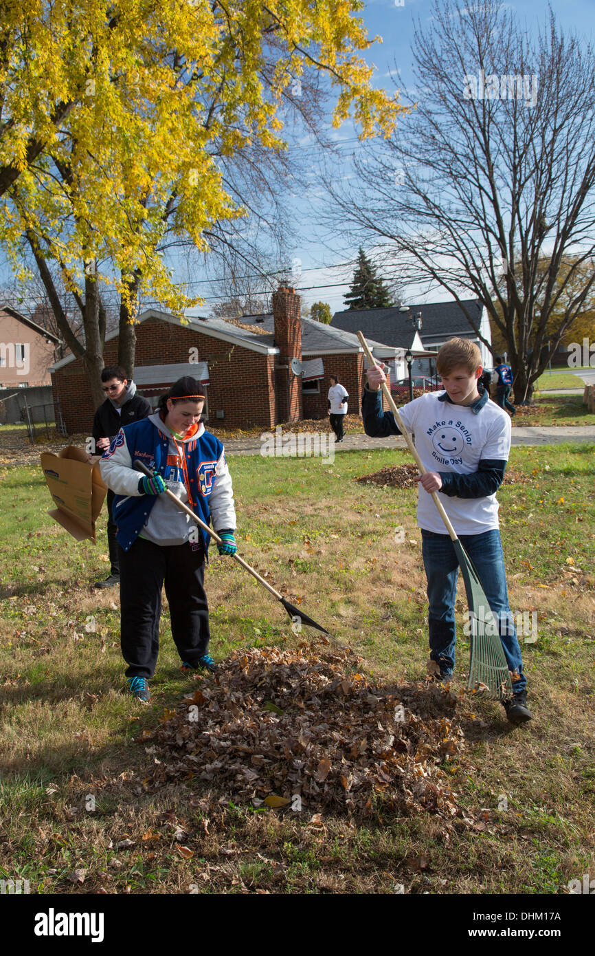 High school student volunteers rake leaves for senior citizens Stock ...