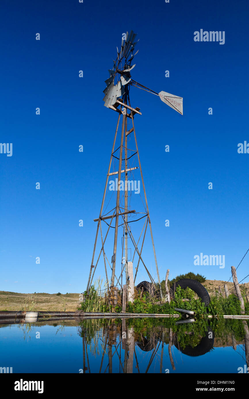 Windmill pumping water for grazing animals and wildlife along Circle ...