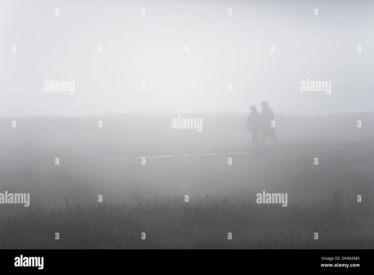 Couple walking in heavy fog off the Pacific Ocean, Laguna Point ...