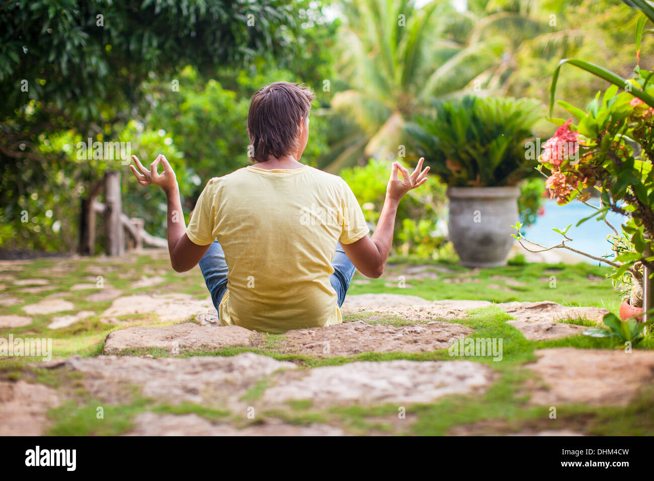 Young man sitting in the lotus position Stock Photo - Alamy