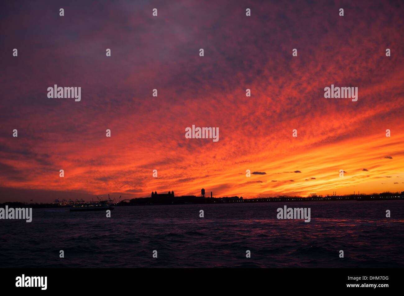 Sunset over New York harbor, Nov. 12, 2013. Ellis Island is silhouetted ...