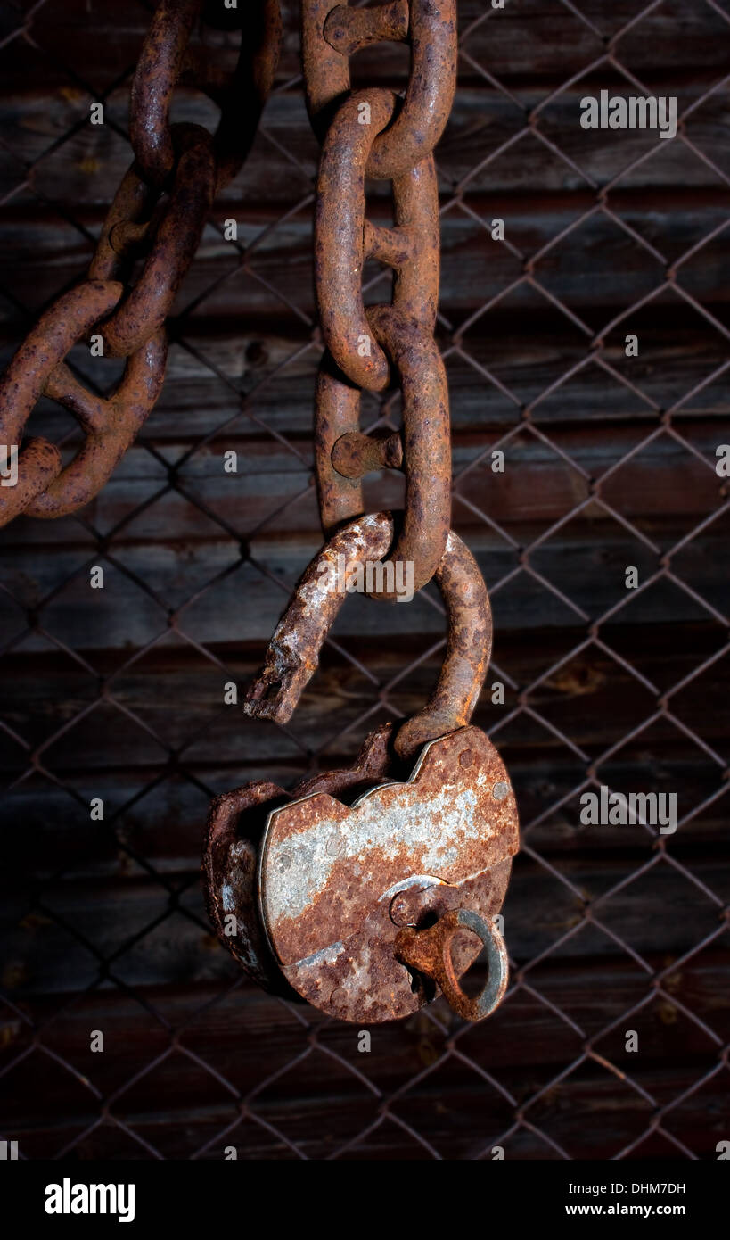 Big old rusty metal open padlock with a key hanging on a bold chain ...
