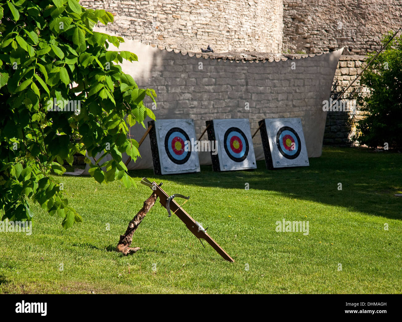 Crossbow and three colorful targets in front of a big curtain wall of ...
