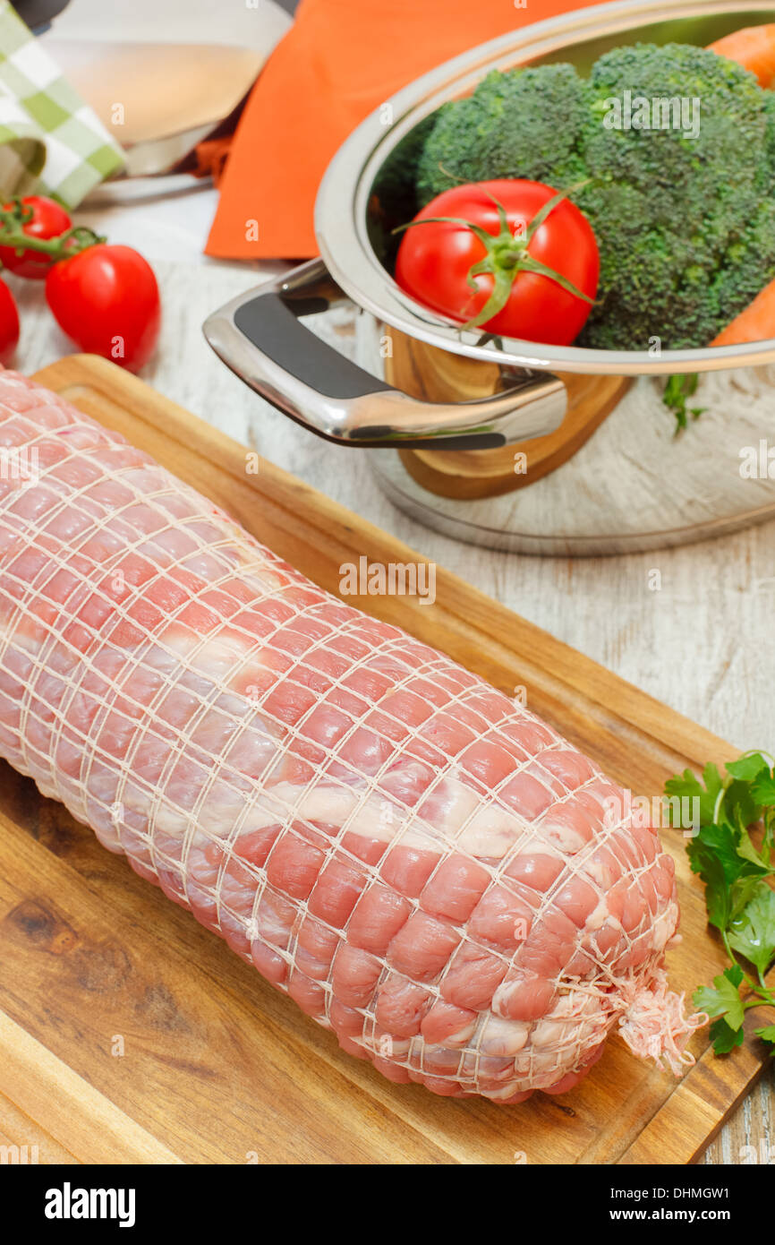 Raw rolled meat enclosed in tied netting. Raw veal meat roll with bacon ...