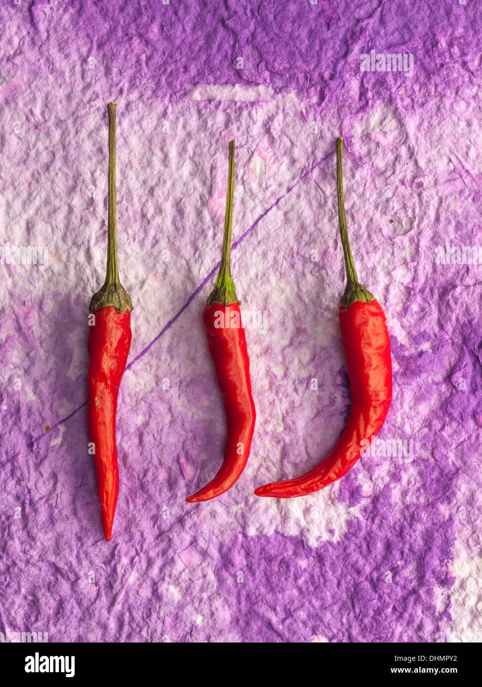 Chilli Peppers on coloured paper backgrounds Stock Photo - Alamy