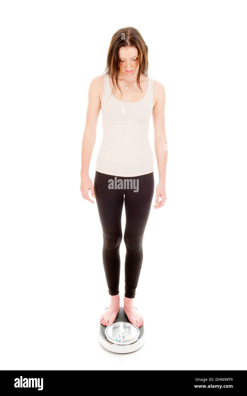 a girl on a weighing scale, disappointed of loosing to too little ...