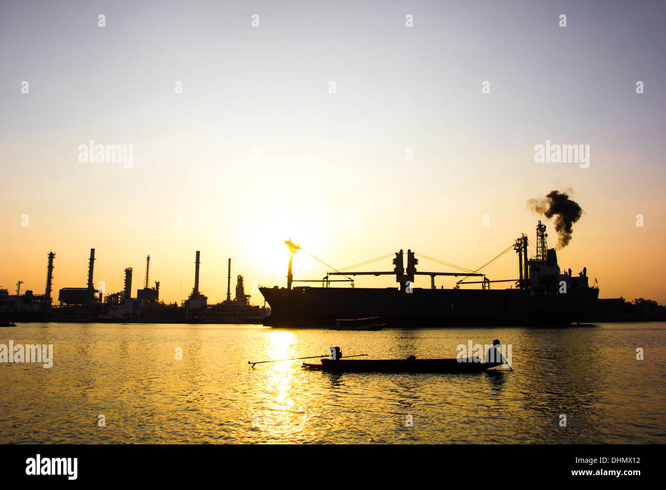 Oil refinery view and freighter with Sunrise Stock Photo - Alamy