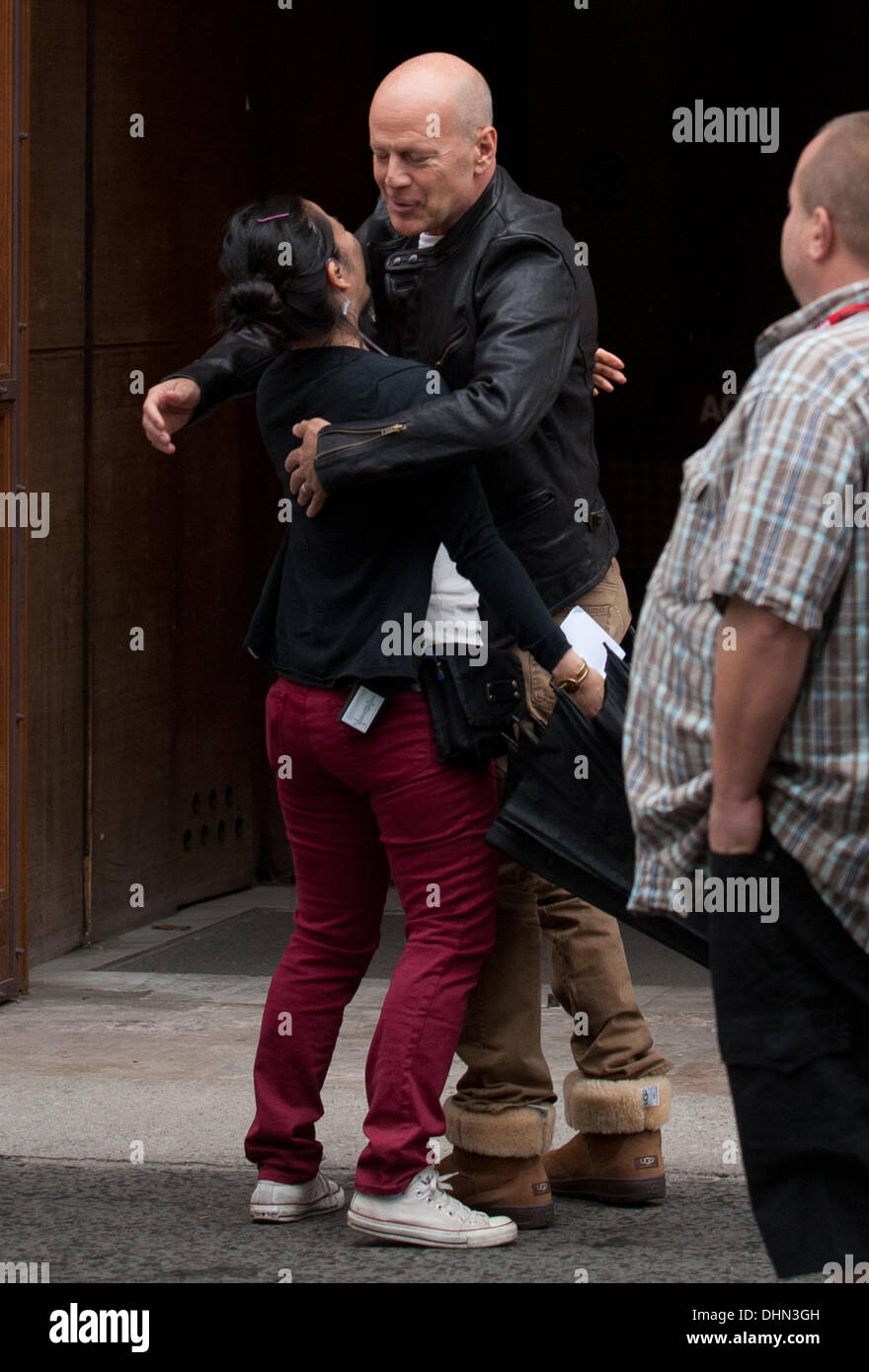 Bruce Willis hugs a friend as he arrives on the film set to shoot ...