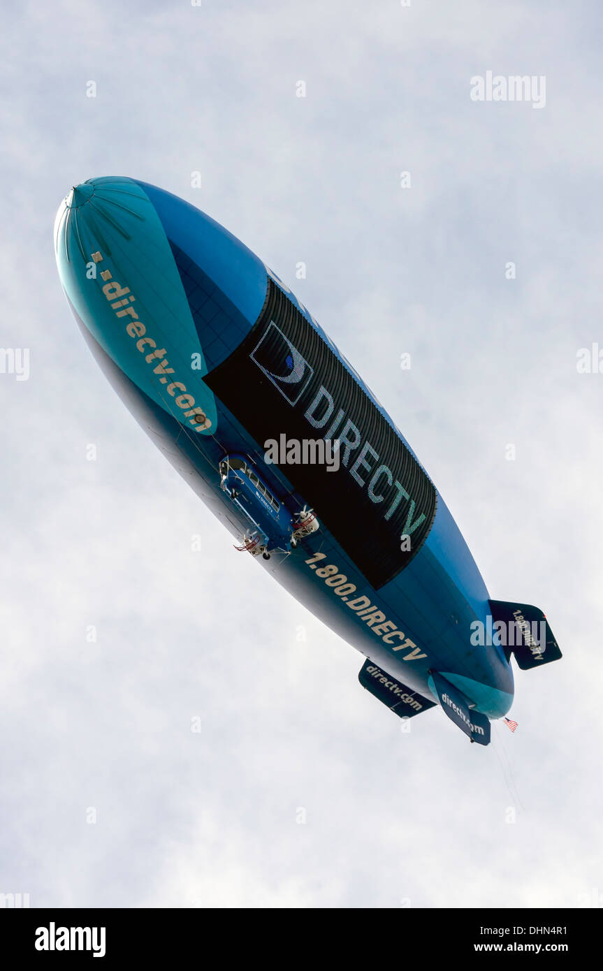 Blue and turquoise hot air blimp navigates above the football stadium ...