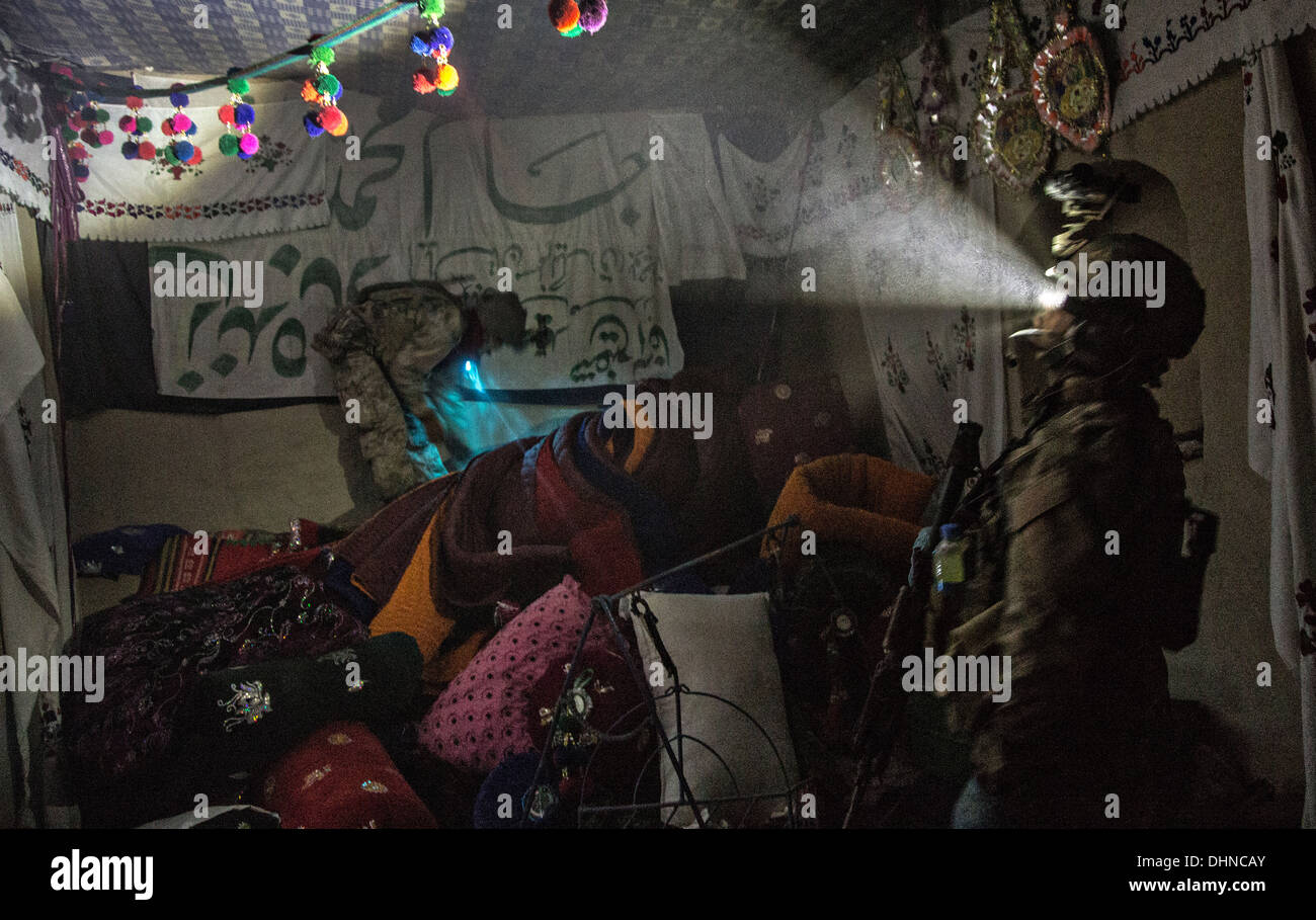 Afghan and US soldiers search a room for evidence during a nighttime ...