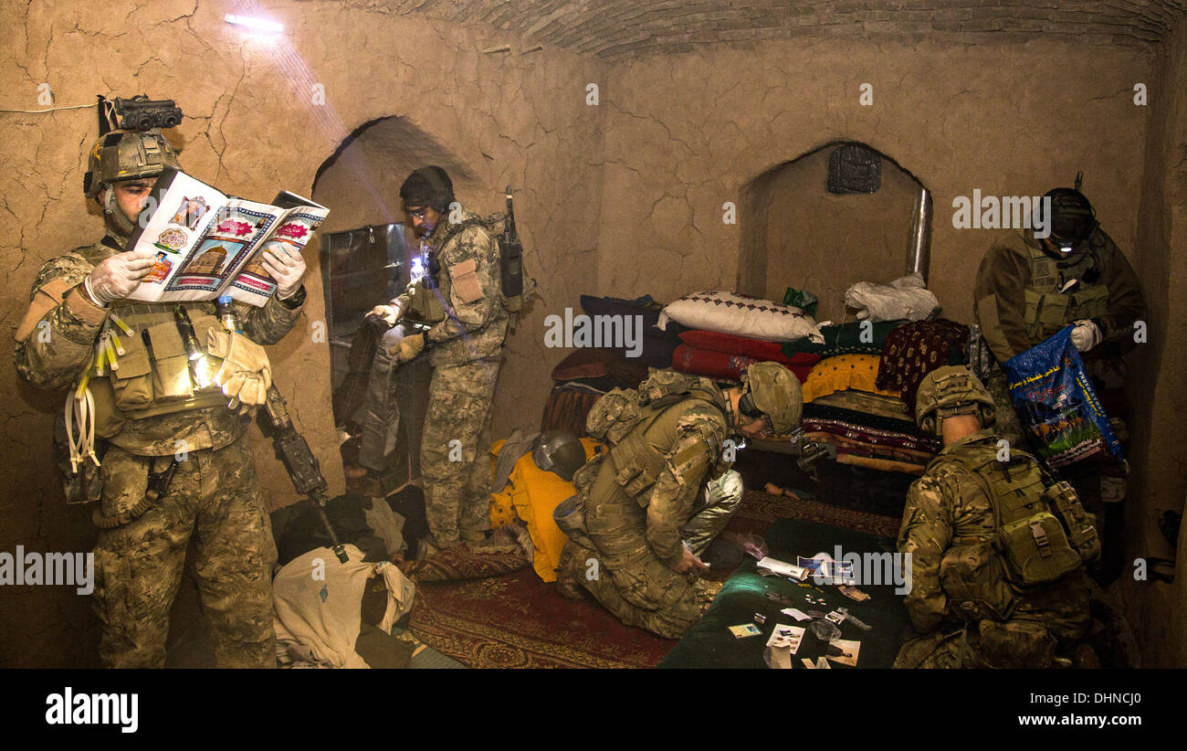 Afghan and US soldiers search a room for evidence during a nighttime ...