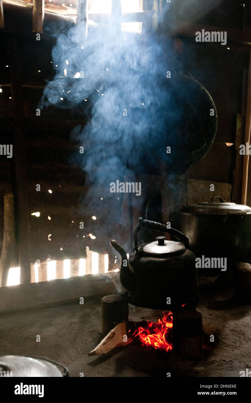 Steam rises from a kettle boiling over an open fire in a home on the ...