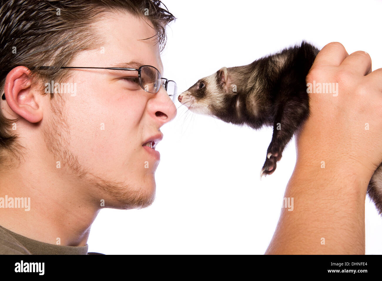 Young man making face at sable ferret isolated on white background ...